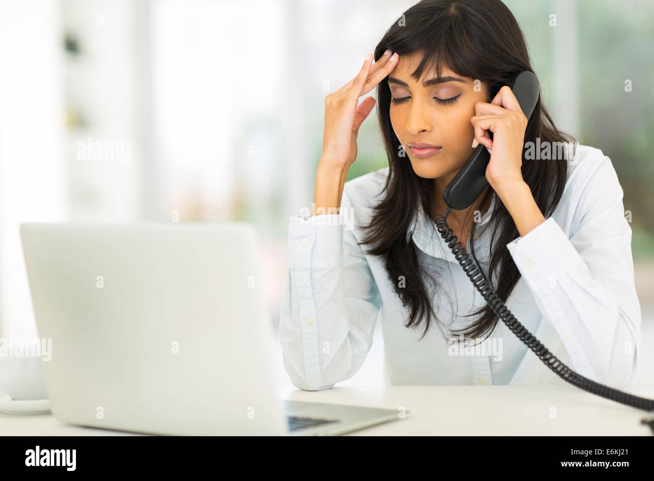 tired Indian businesswoman using landline phone Stock Photo - Alamy