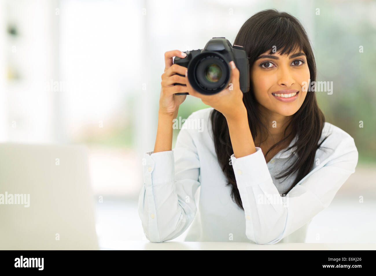 smiling Indian photographer holding a dslr camera in office Stock Photo ...
