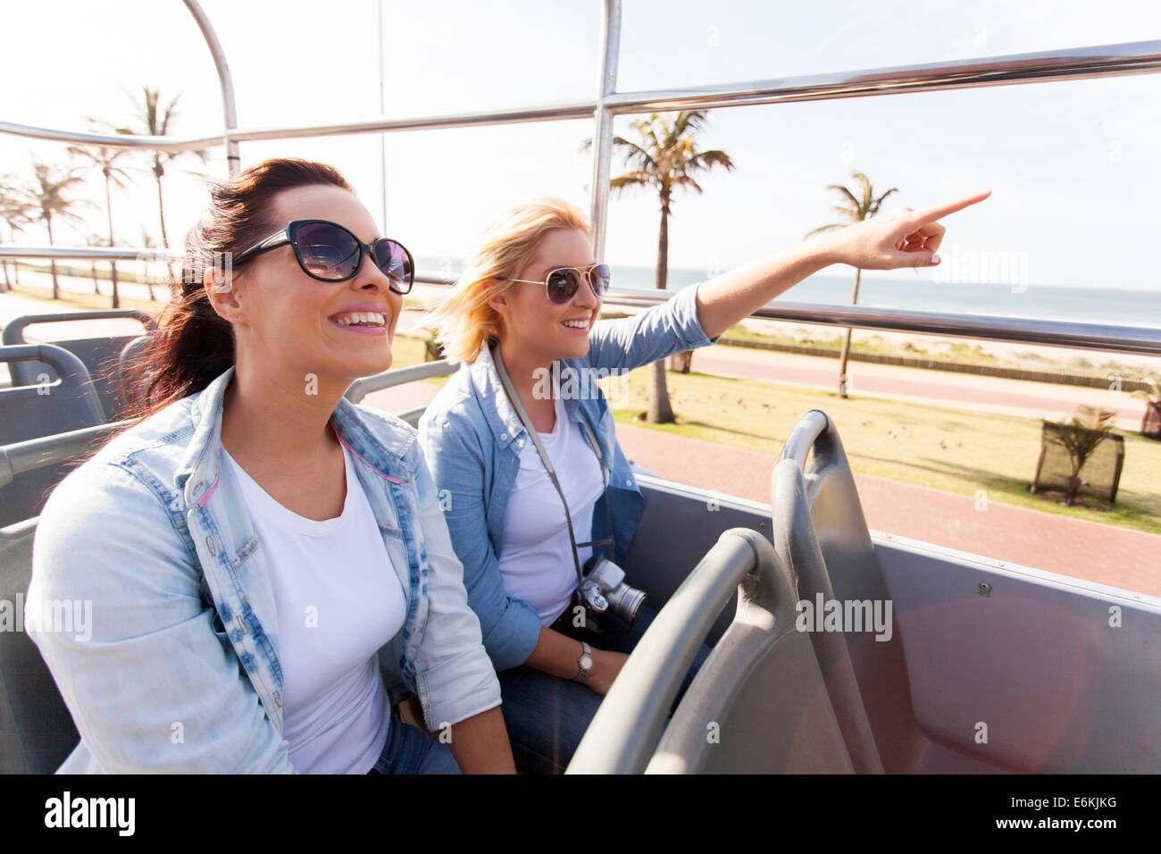 two happy friends taking city bus touring the town Stock Photo - Alamy