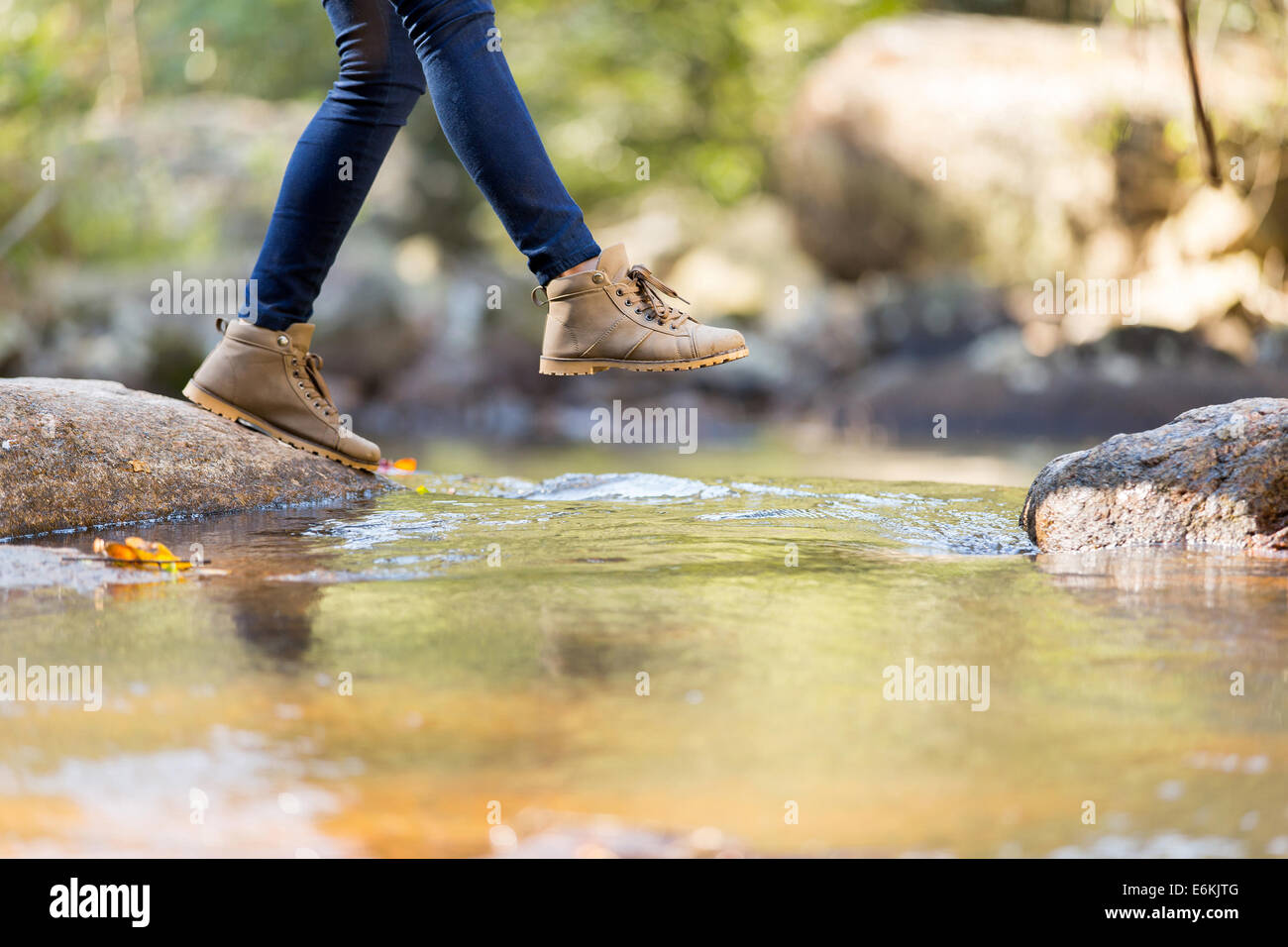 young woman hiking in mountain crossing stream Stock Photo - Alamy