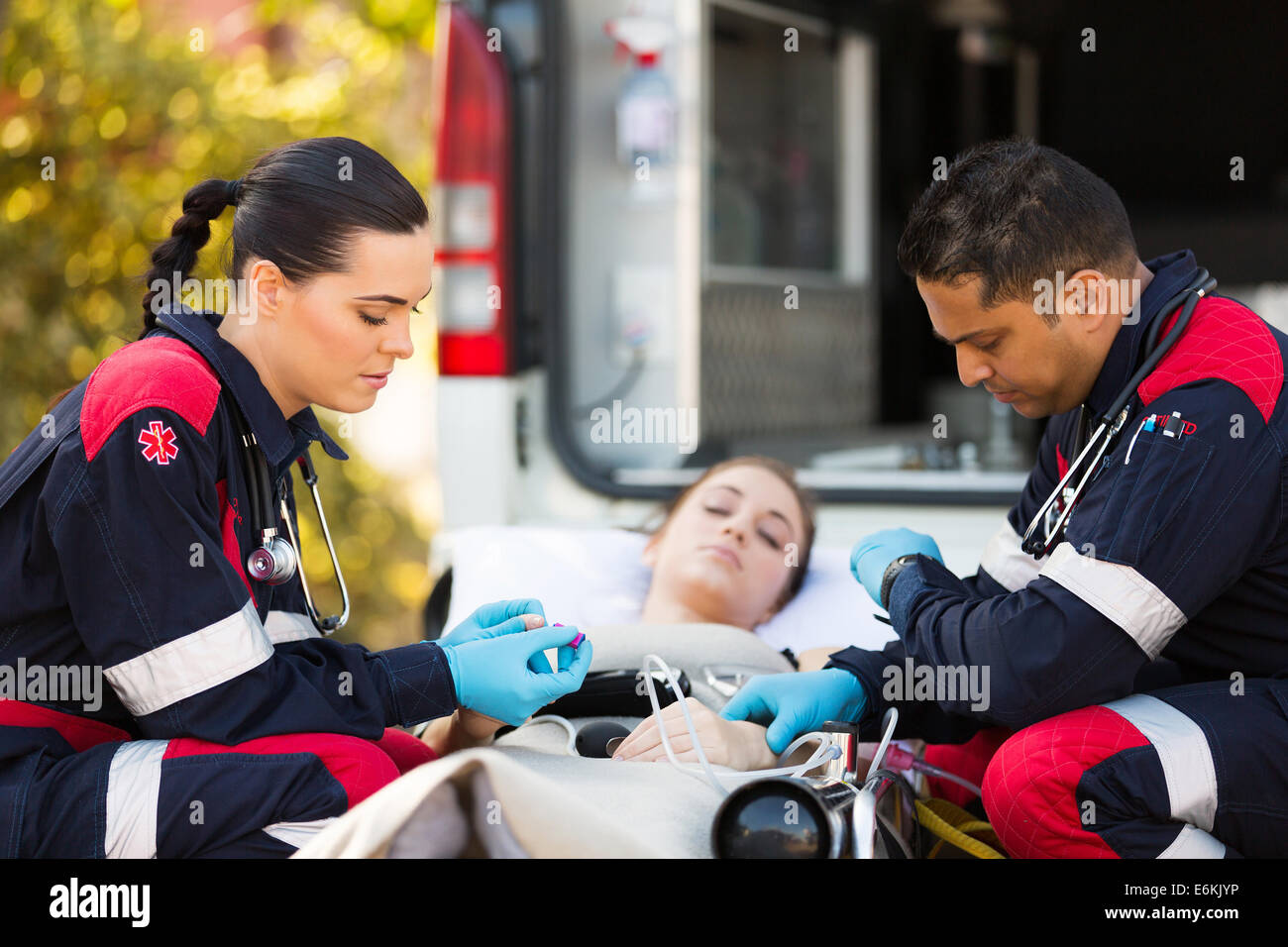 professional paramedics giving unconscious young woman first aid Stock ...