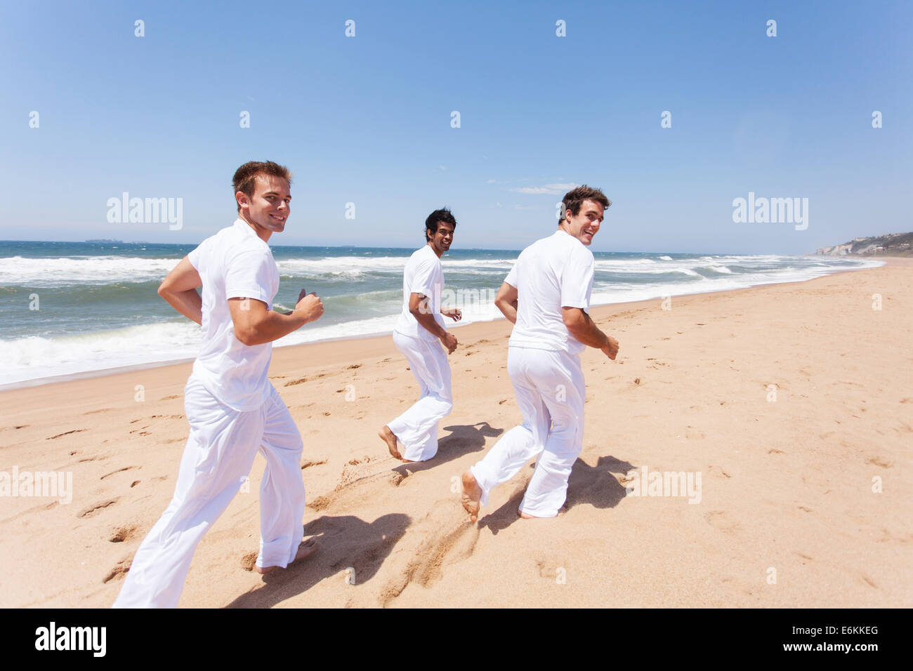 group of friends jogging on the beach Stock Photo - Alamy