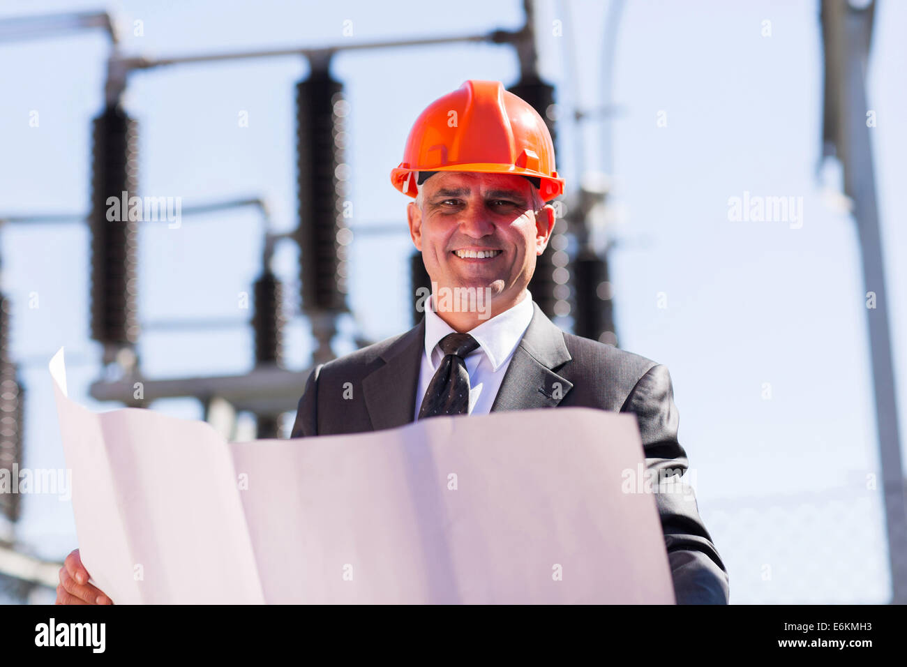 good looking middle aged electrical manager with blueprint Stock Photo ...