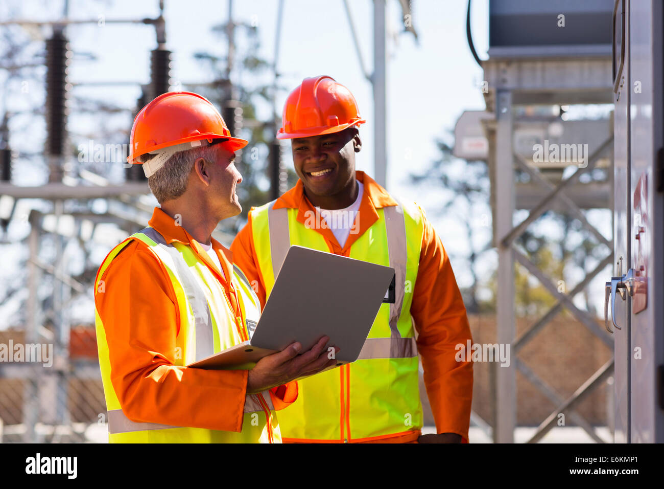 happy electricians using laptop computer in electrical substation Stock ...