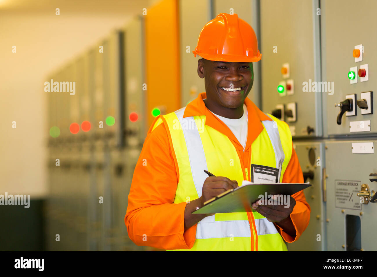 happy African American engineer standing in front of control panel ... happy African American engineer standing in front of control panel ...