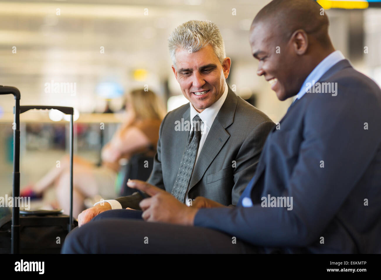 two professional business partners at airport waiting for their flight ...