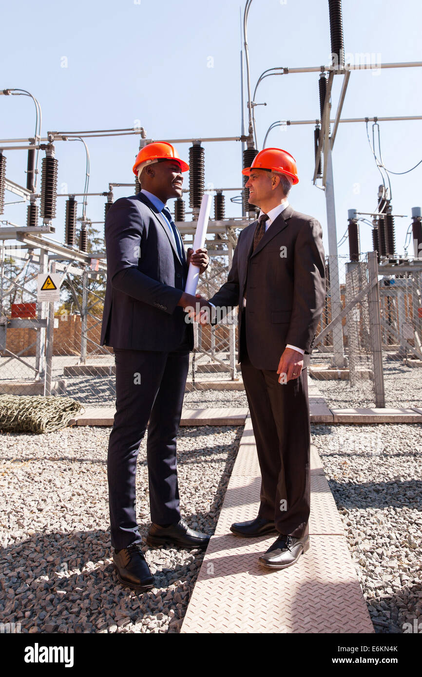 power company managers handshaking in electrical substation Stock Photo ...