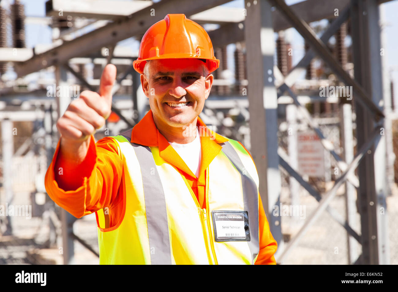 happy senior power company technician giving thumb up in substation ...