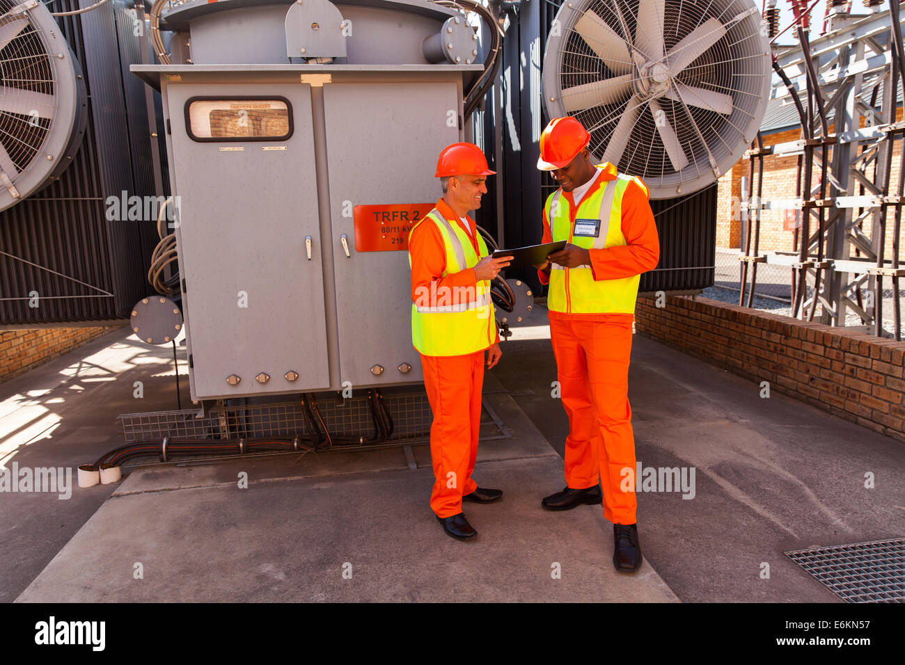 two electrical engineers working together in front of transformer Stock ...