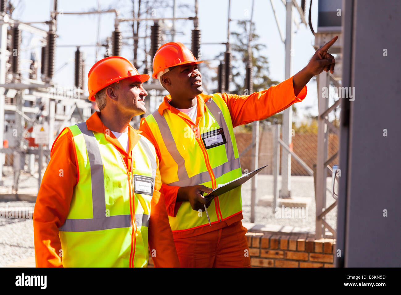successful electrical engineers taking machine readings in substation ...