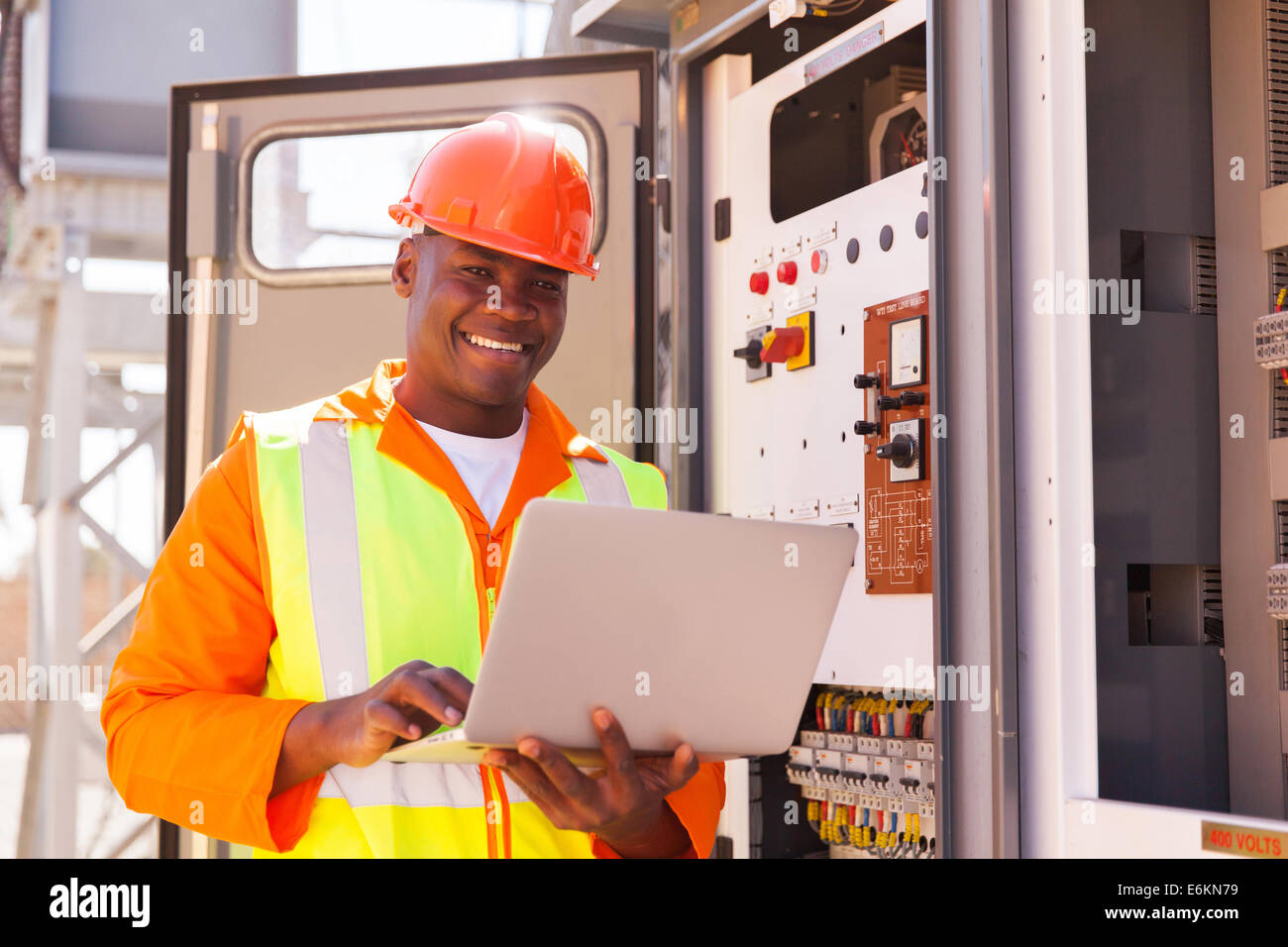 portrait of happy young African electrical engineer with laptop Stock ...