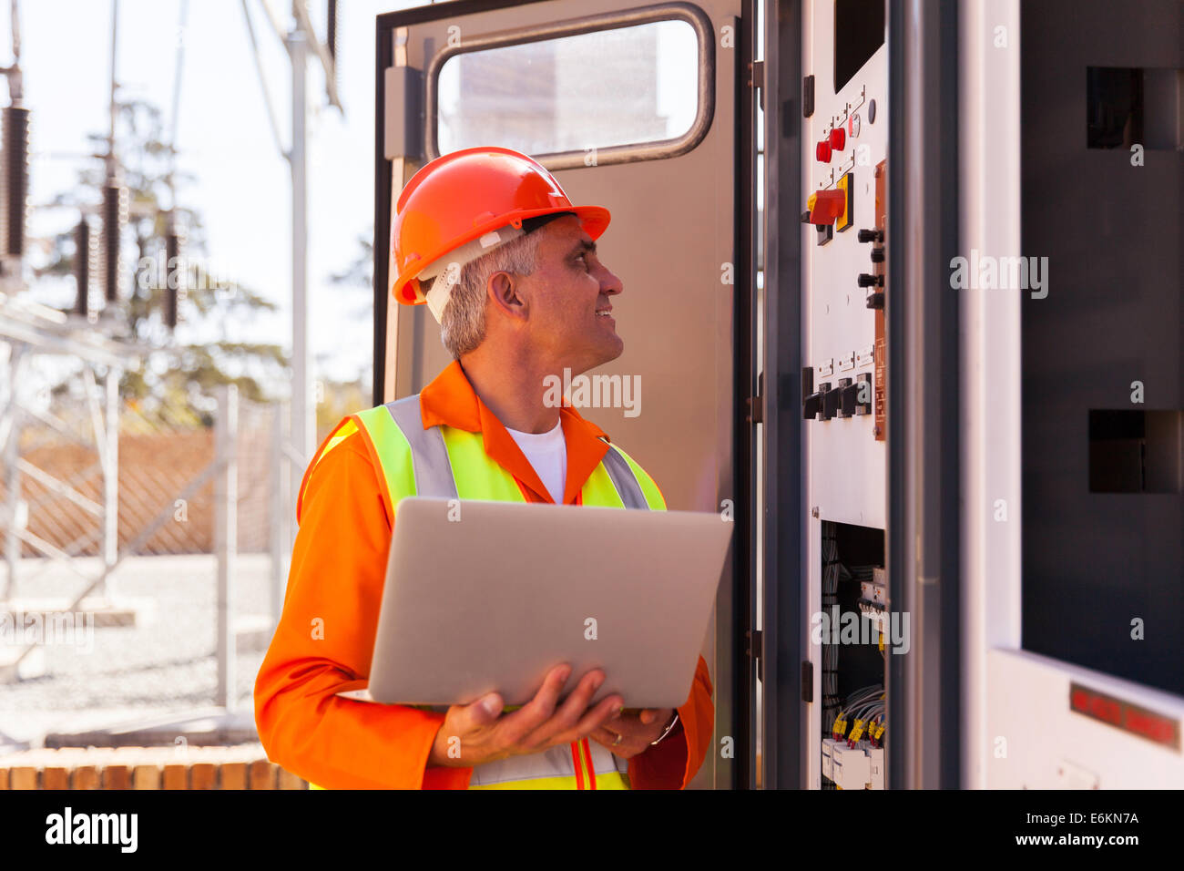 experienced senior electrician working on a transformer in substation ...