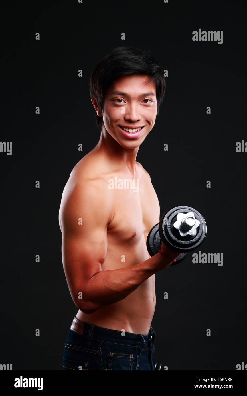 Smiling asian man working out with dumbbell on black backgroung Stock ...