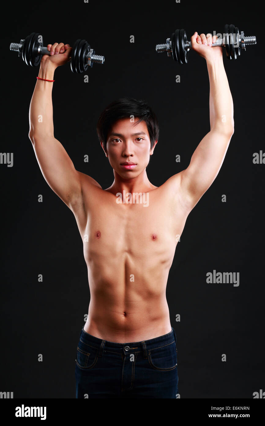 Asian man working out with dumbbell on black background Stock Photo - Alamy