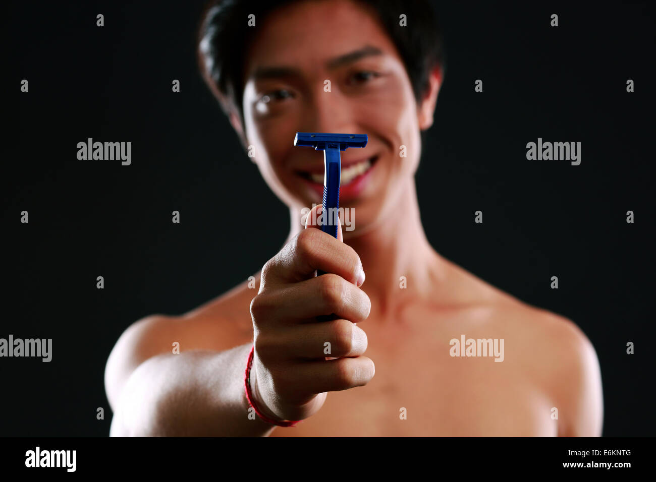 Asian man holding razor. Focus on razor Stock Photo - Alamy