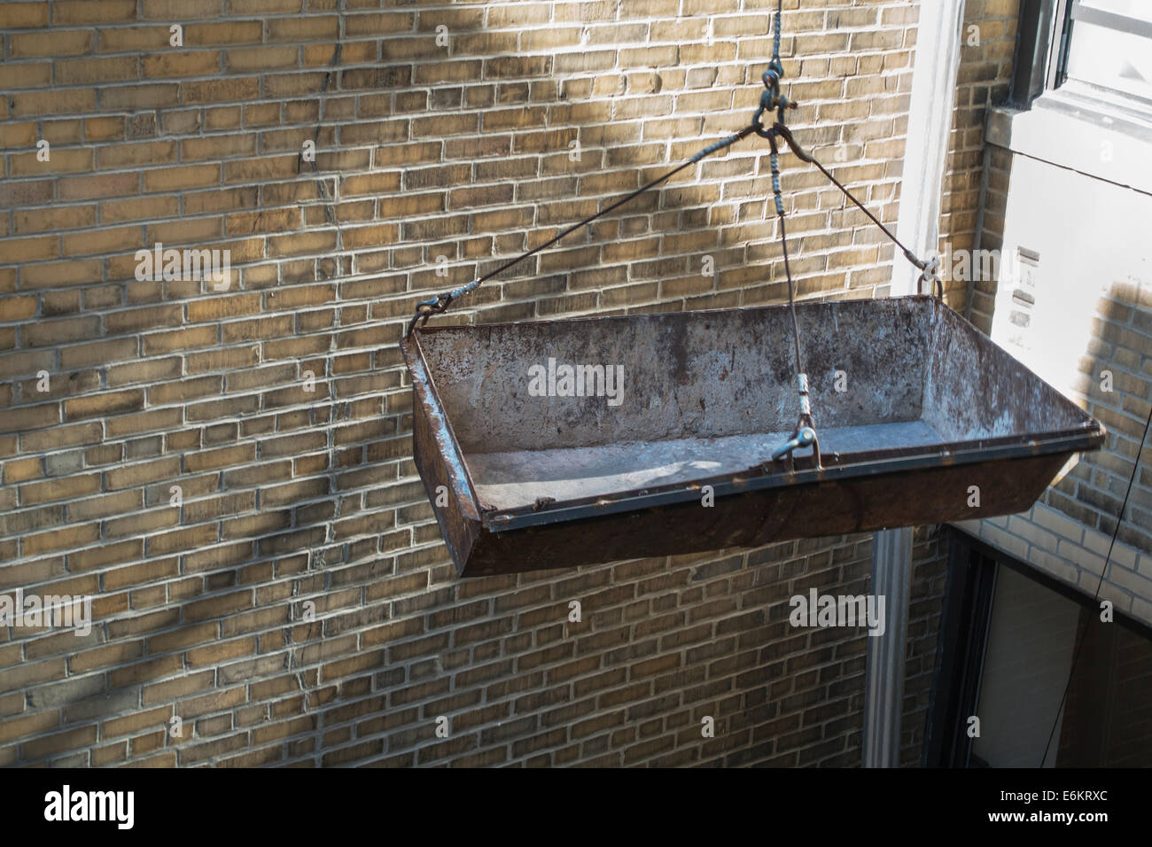 empty construction bucket on hoist on side of brick building Stock ...
