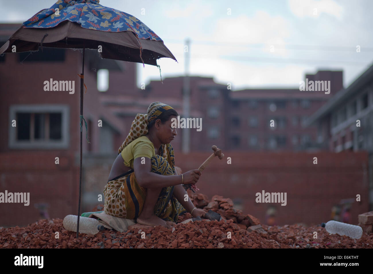 Dhaka, Bangladesh. 26th Aug, 2014. An women crushing bricks for uses of ...