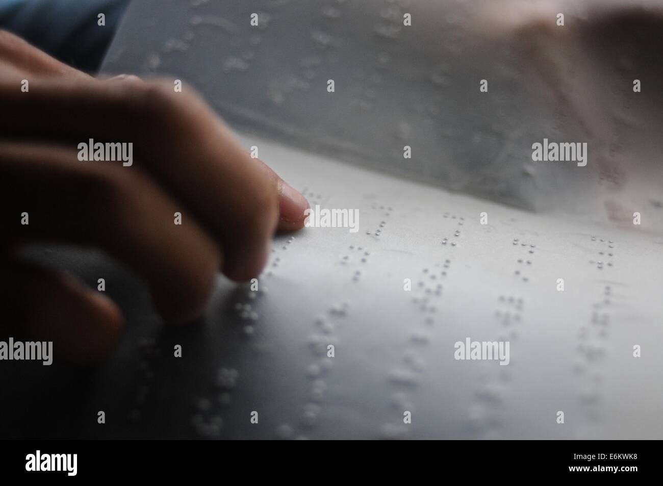 Blind man reading from a page written in braille Stock Photo - Alamy