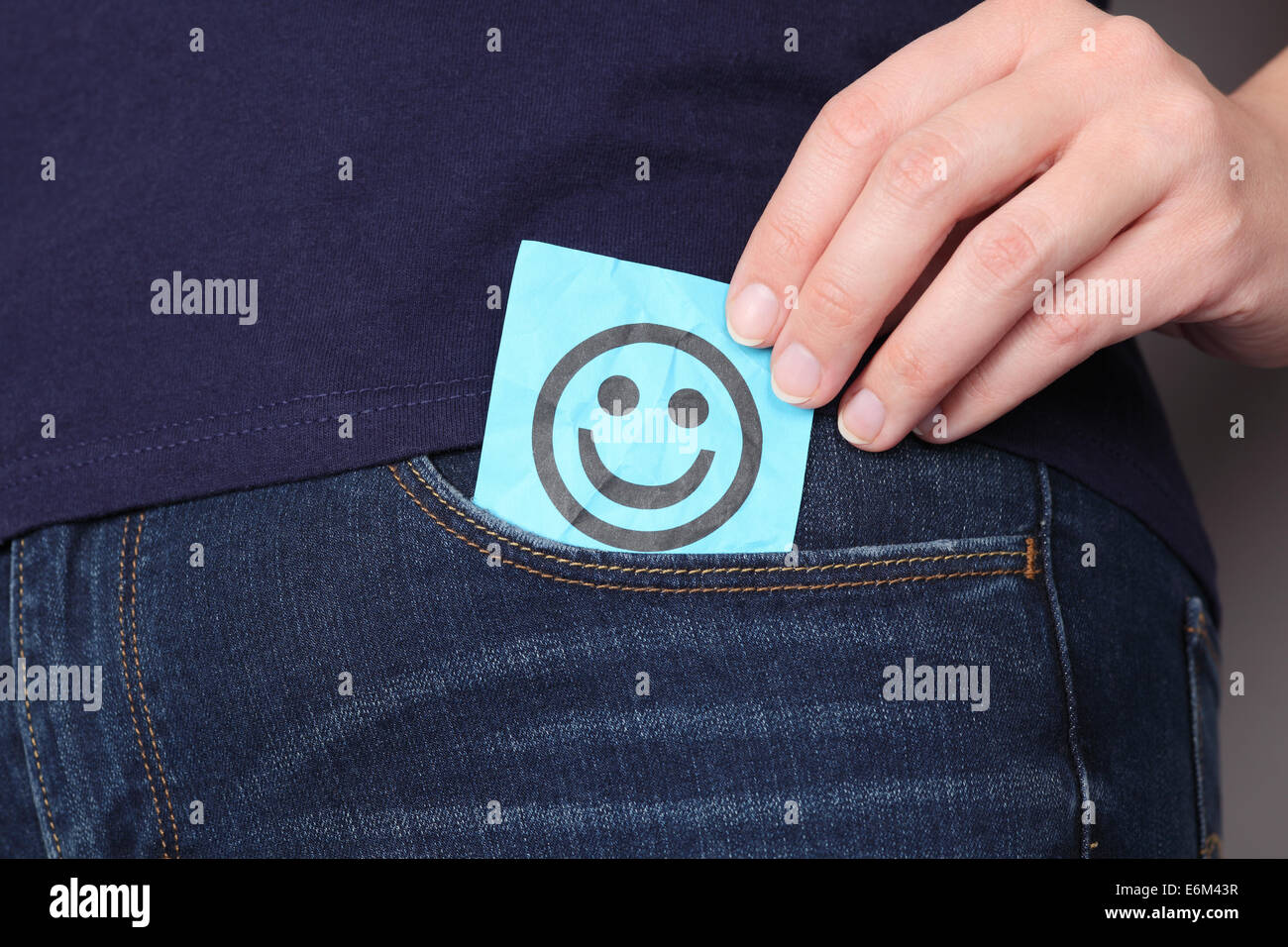 Woman's hand takes out paper note with smiling face from pocket of her ...