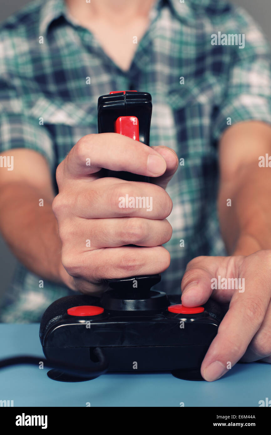 Young man plays video game with a retro joystick. Gaming joystick from ...