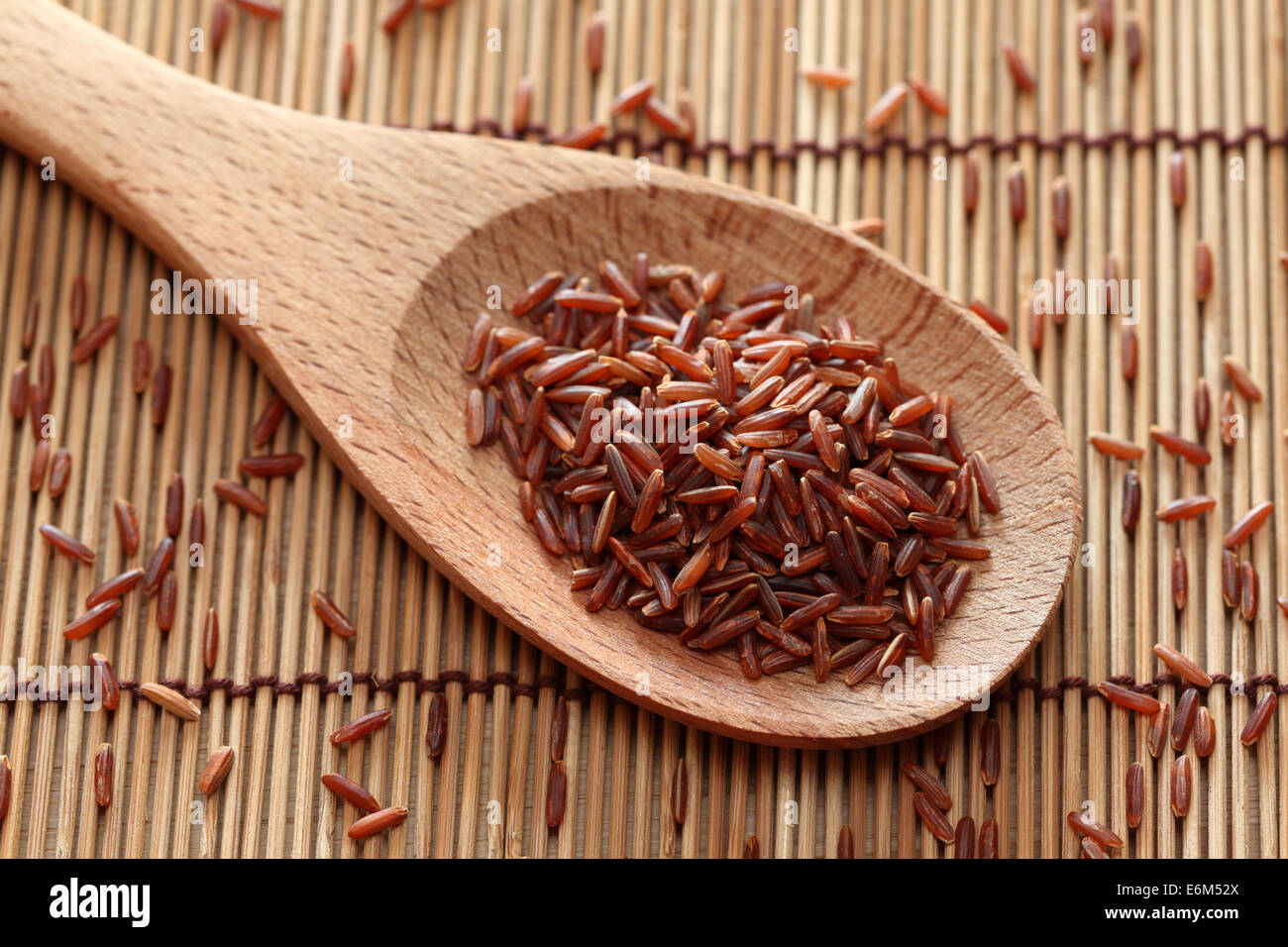 Red rice in a wooden spoon. Closeup Stock Photo - Alamy
