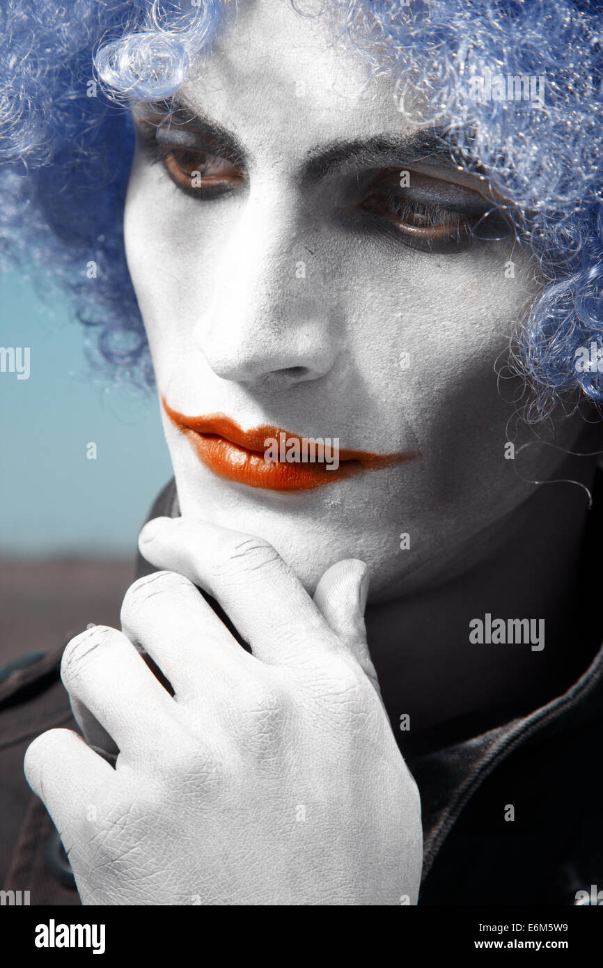 Pensive clown with blue wig. Vertical colorful portrait Stock Photo - Alamy