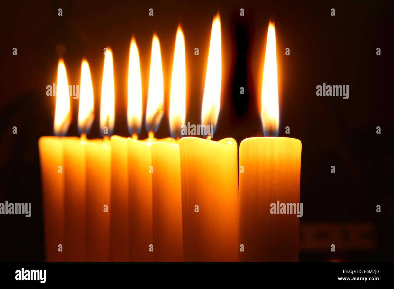 Eight burning candles over black background Stock Photo - Alamy