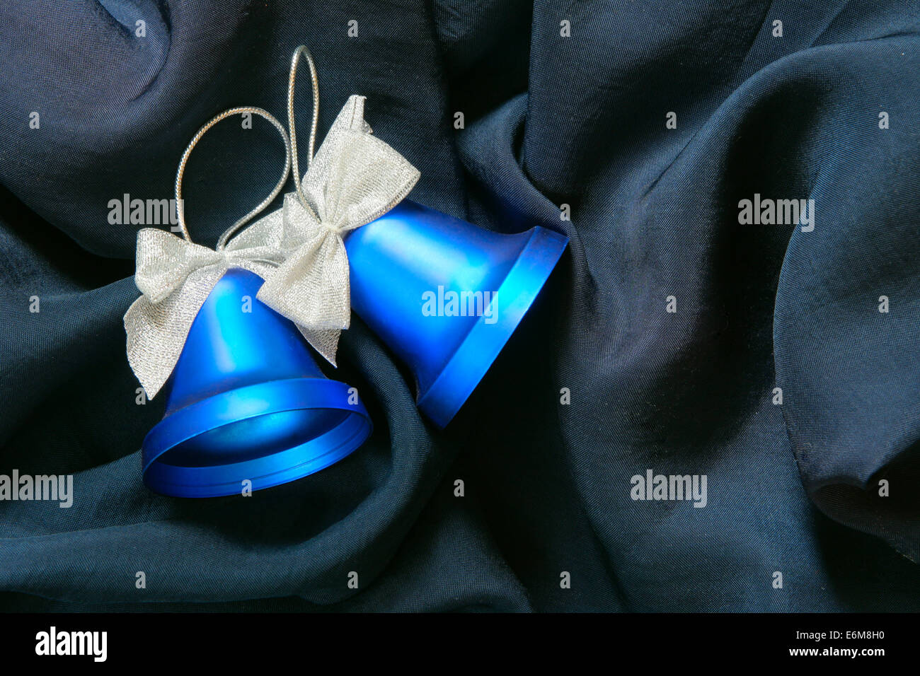 Two Christmas bells over dark blue fabric background Stock Photo - Alamy