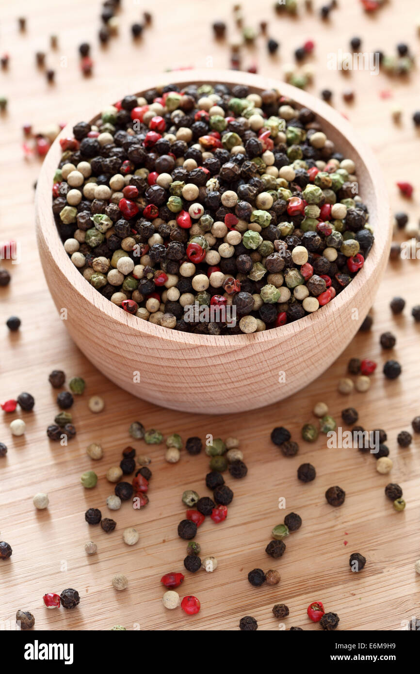 Mixed peppercorns in a wooden bowl. Closeup Stock Photo - Alamy