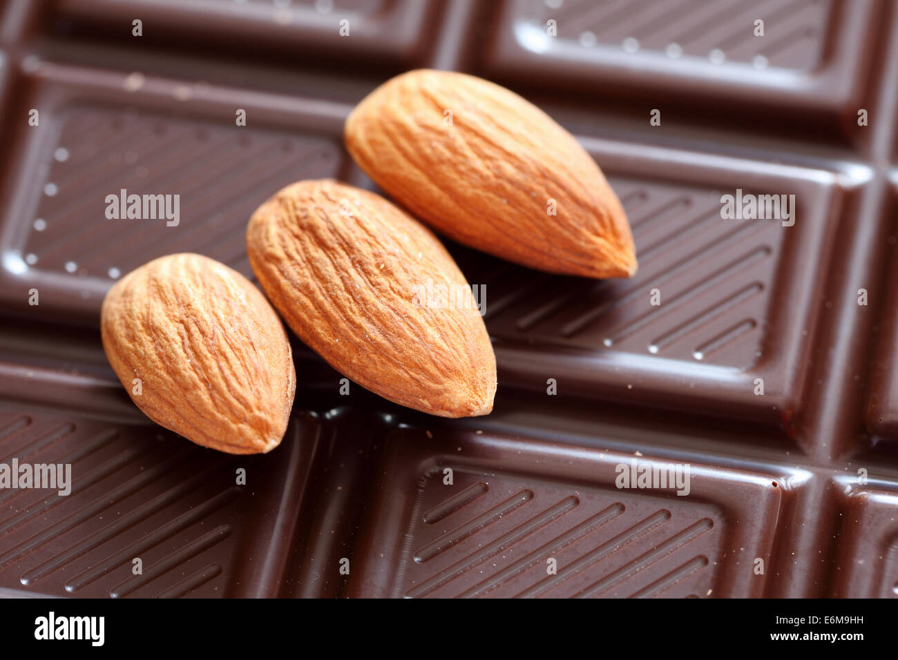 Three almonds on chocolate background. Closeup Stock Photo - Alamy
