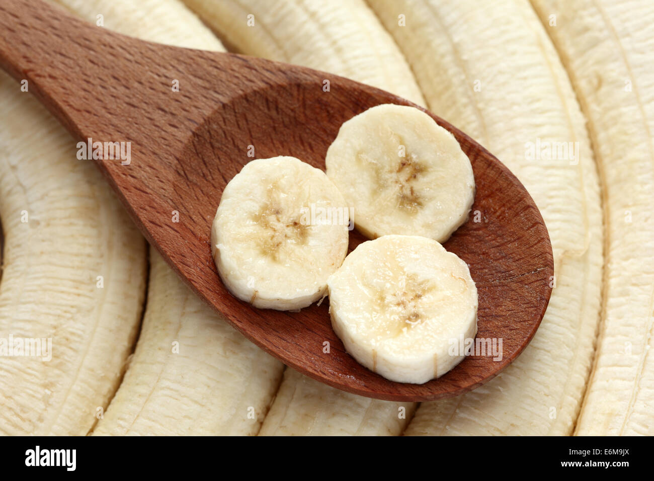 Bananas in a wooden spoon on bananas background. Closeup Stock Photo ...