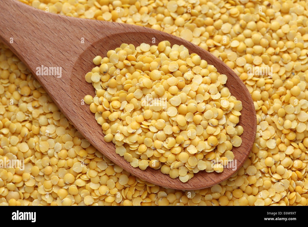 Yellow lentils in a wooden spoon on yellow lentils background Stock ...