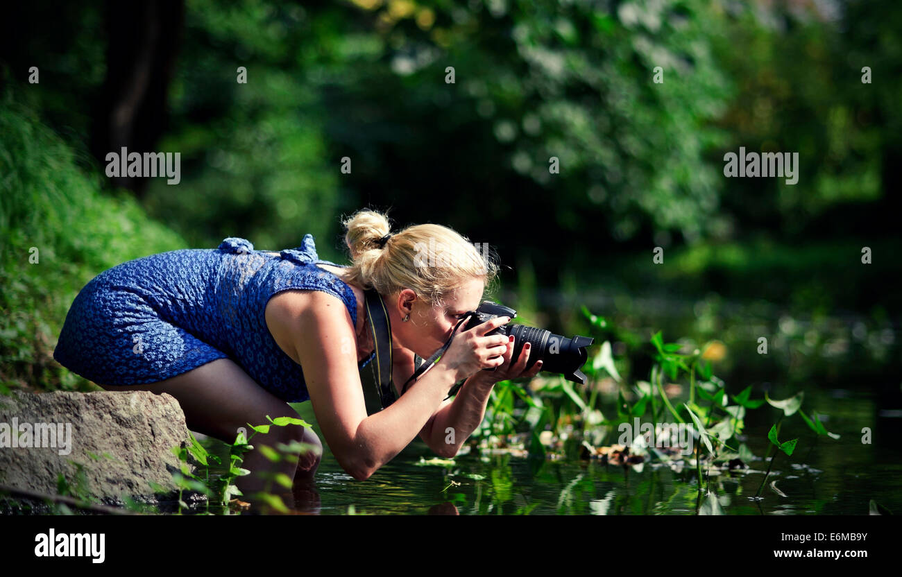 Beautiful girl taking photo at riverside Stock Photo - Alamy