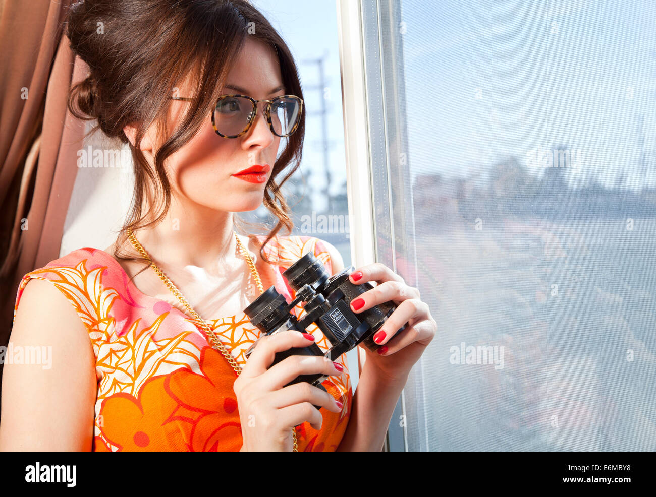 Young woman looking through window Stock Photo - Alamy