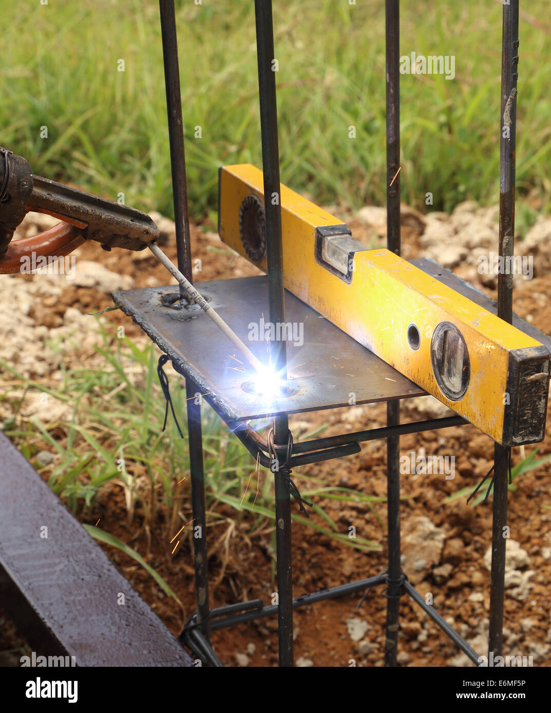 electric welding connecting metal rod and metal plate with level meter ...