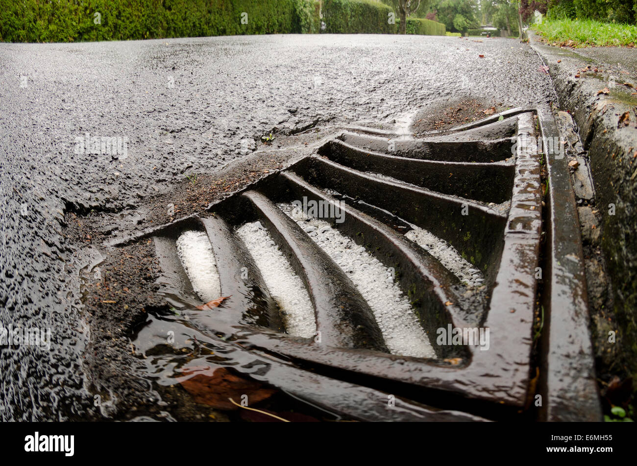 Blocked overflowing roadside drain tarmac highway leading to more ...