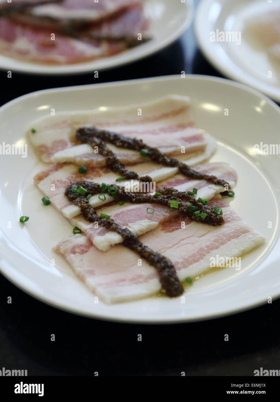 Fresh bacon strips with sauce on plate Stock Photo - Alamy