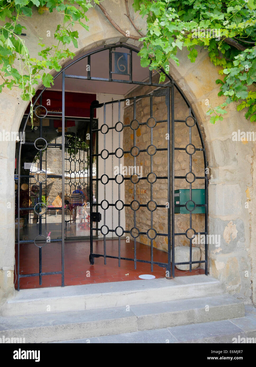 Restaurant courtyard entrance with wrought iron gate, Mirepoix France ...