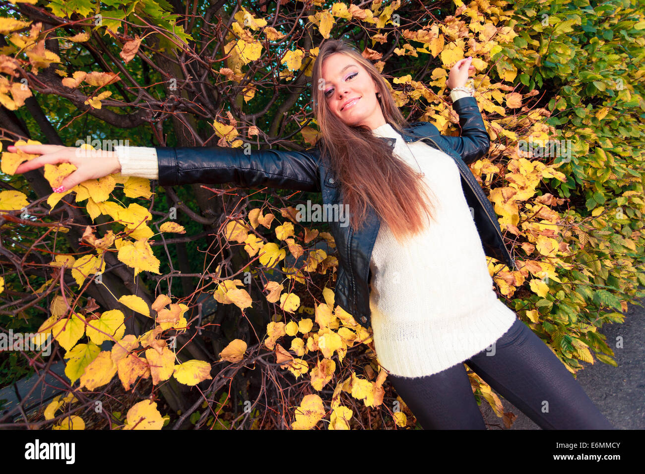 Fall season. Portrait of happy girl young woman lying on the colorful ...