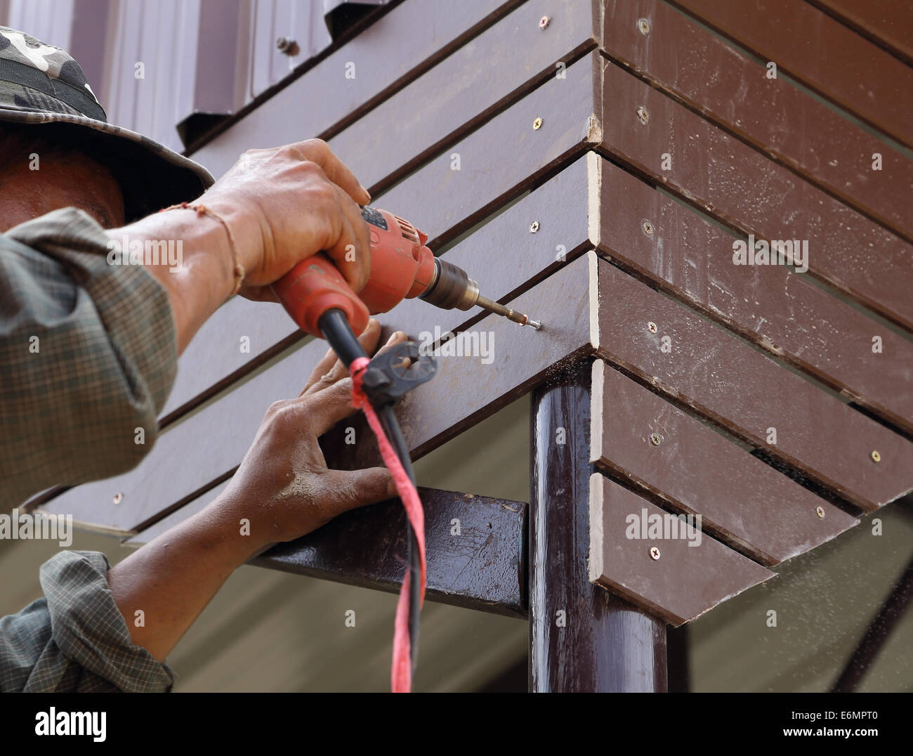 carpenter at lock installation with electric drill into construction ...