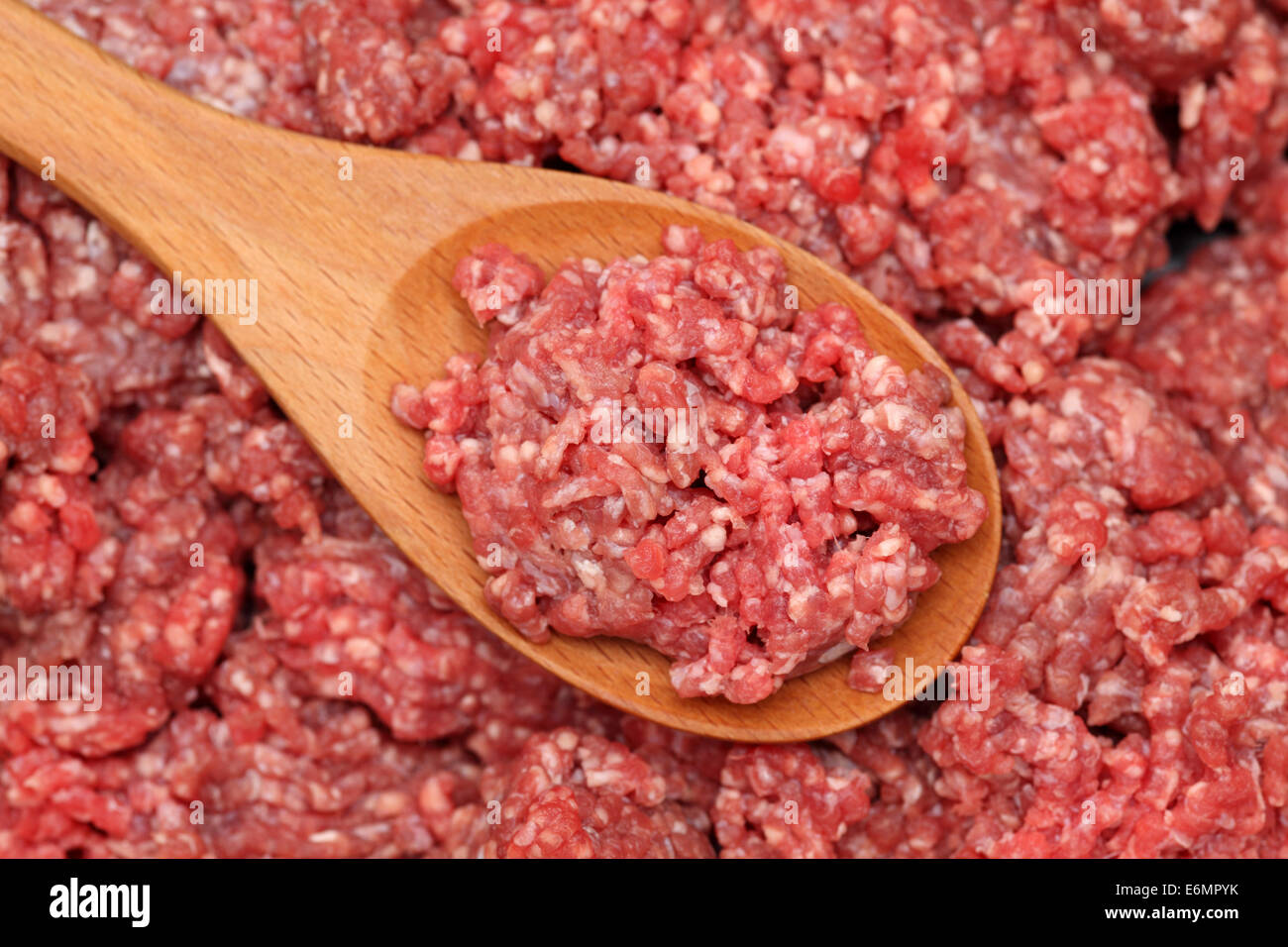 Minced meat in a wooden spoon. Close-up Stock Photo - Alamy