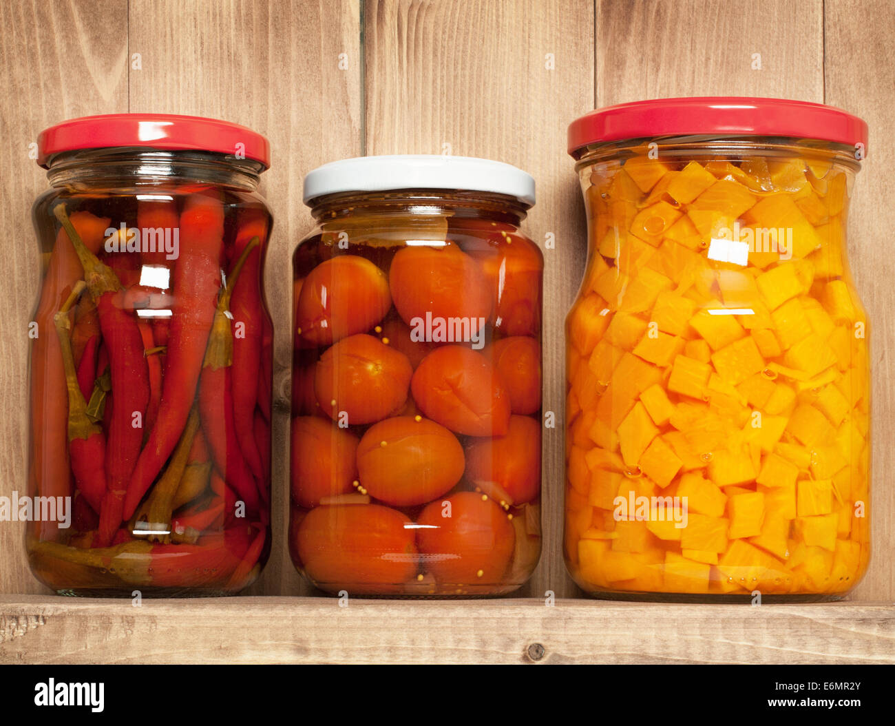 Preserved vegetable on shelf near a brown wooden wall Stock Photo - Alamy