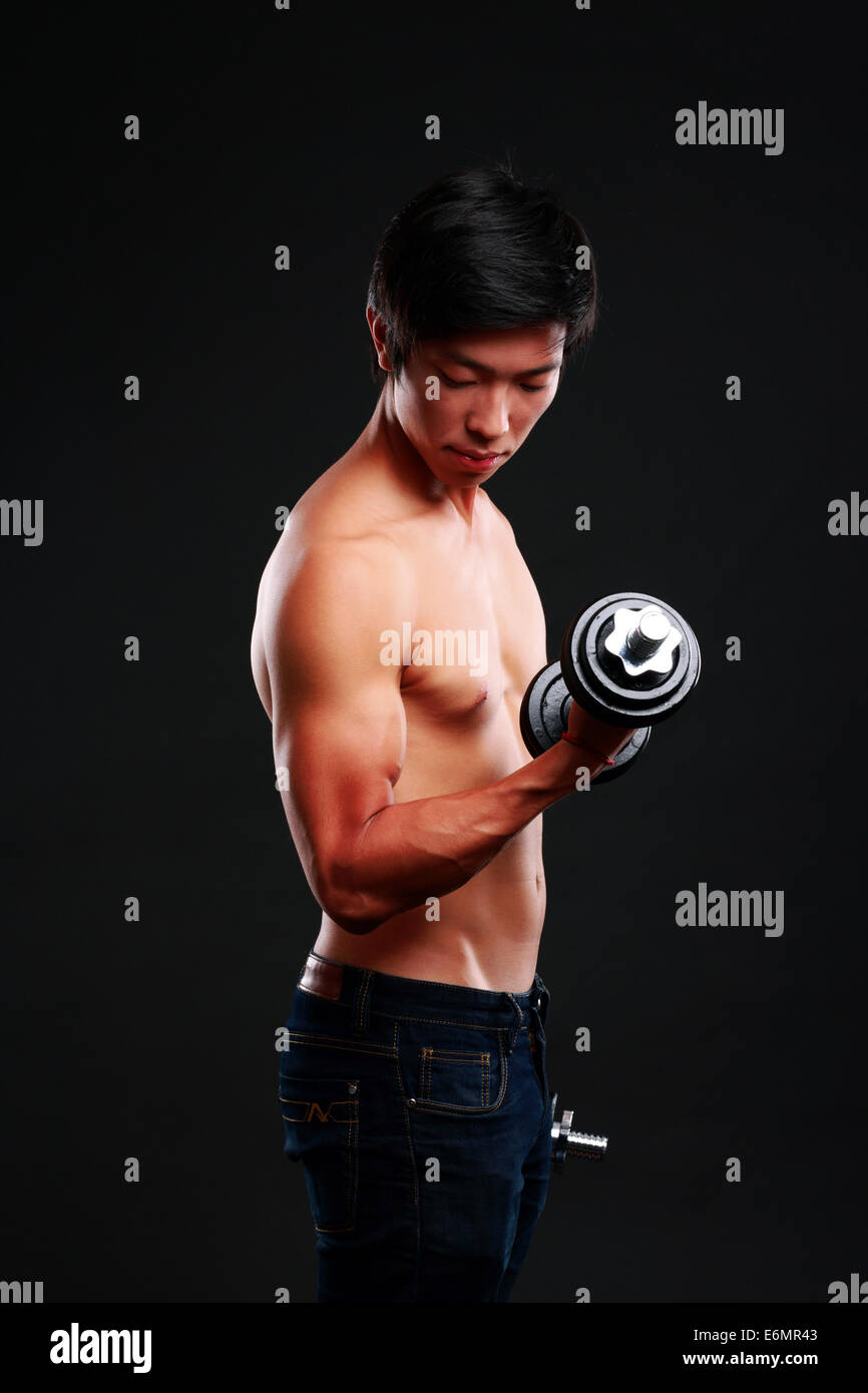 Asian man working out with dumbbell on black background Stock Photo - Alamy