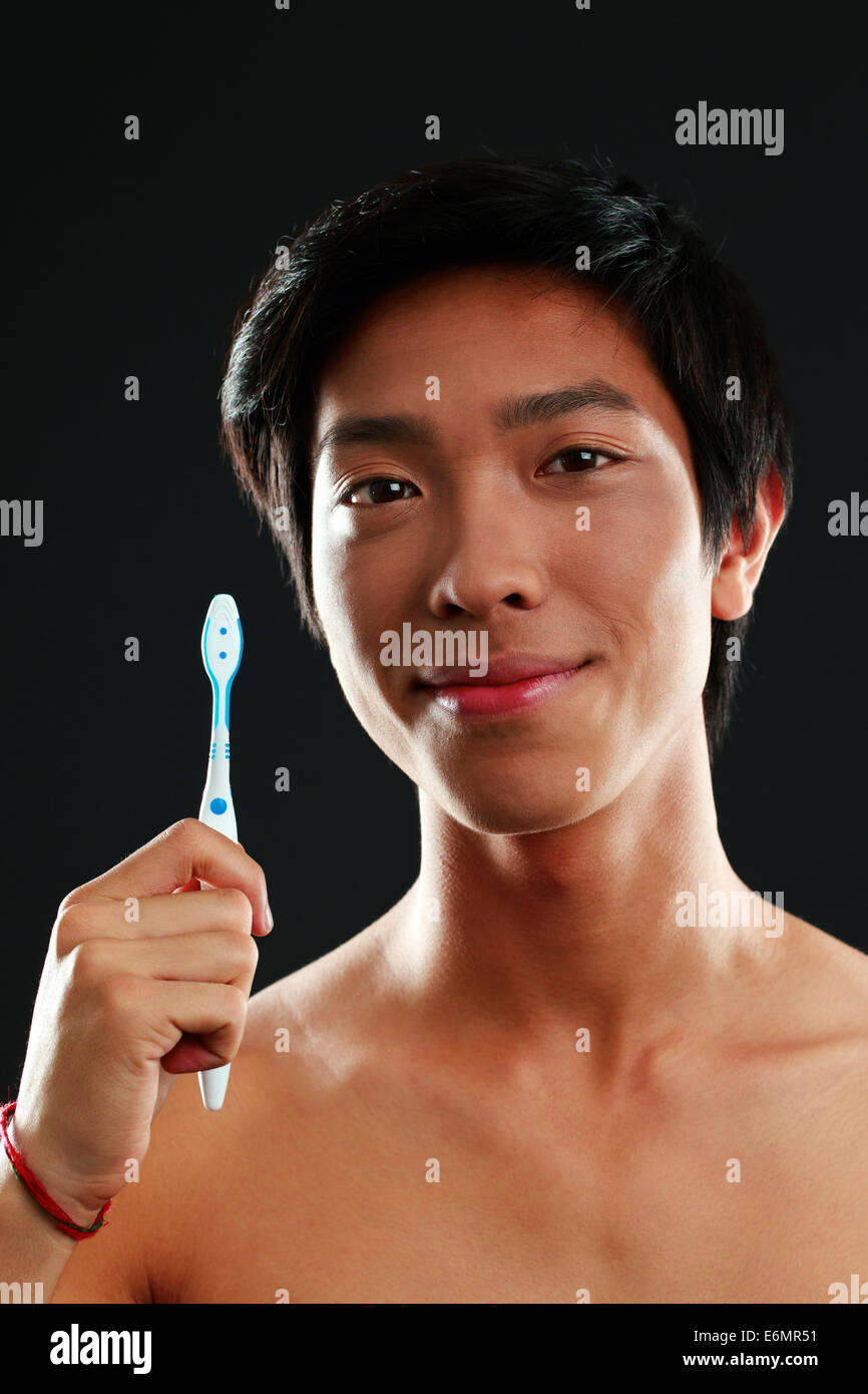 Portrait of a young man with toothbrush on black background Stock Photo ...