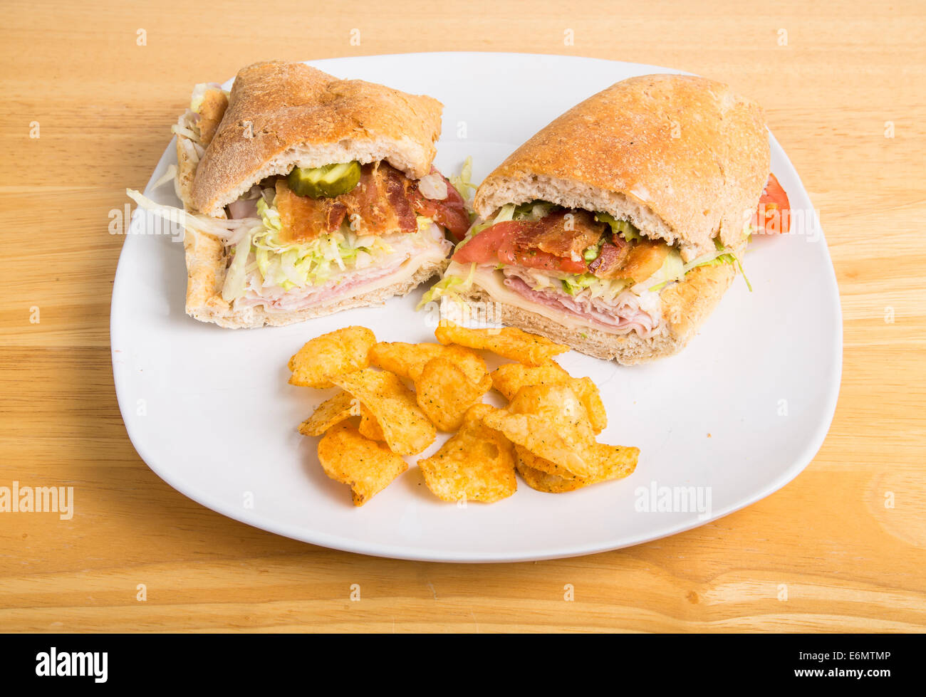 A fresh, sub sandwich on a plate with potato chips Stock Photo - Alamy