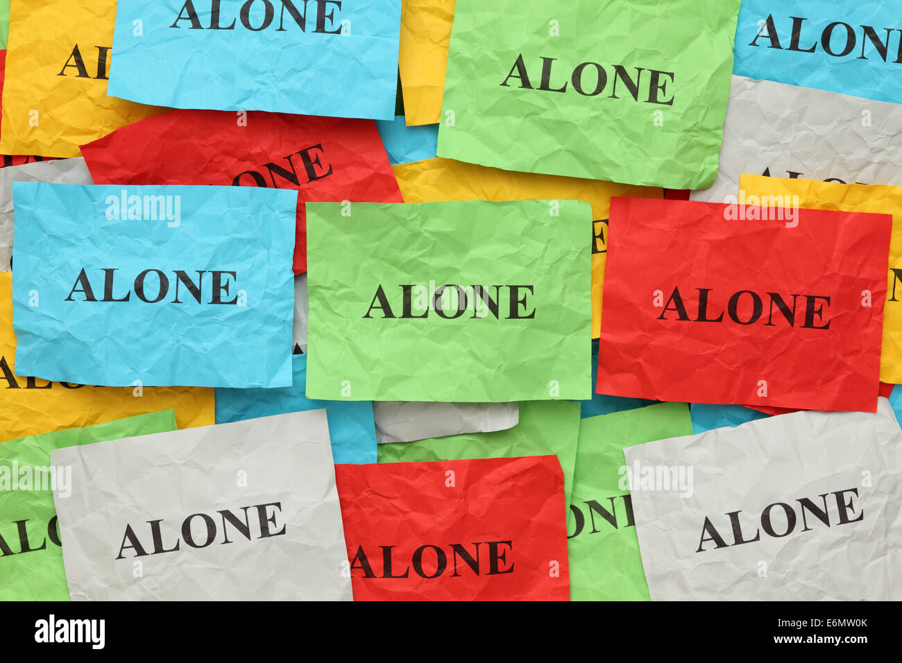 Crumpled colorful paper notes with word "Alone Stock Photo - Alamy