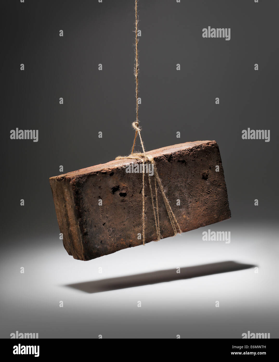Old worn and weathered brick hanging on a string Stock Photo - Alamy
