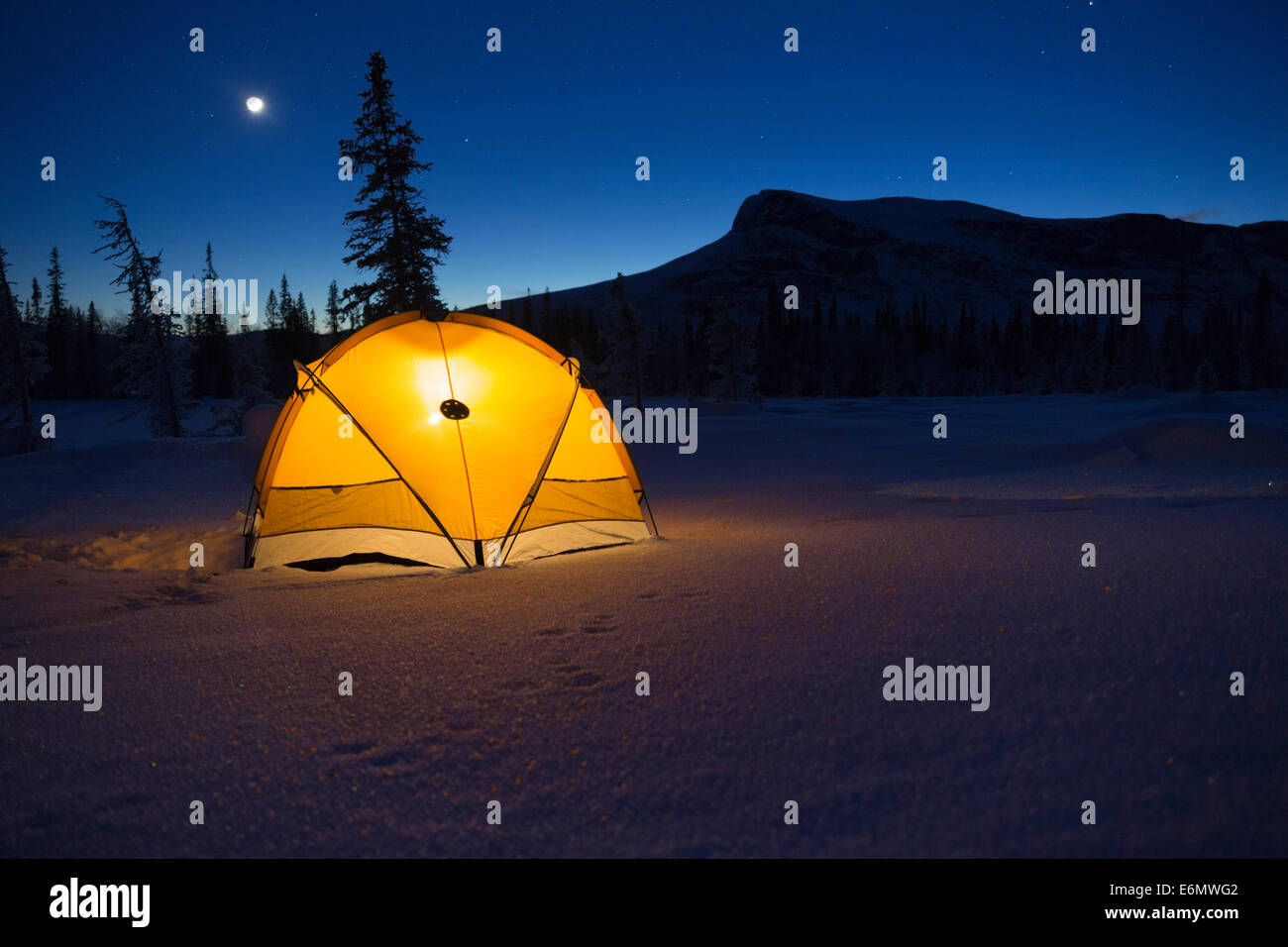 Tent in winter landscape with lantern in side the tent with moon ...