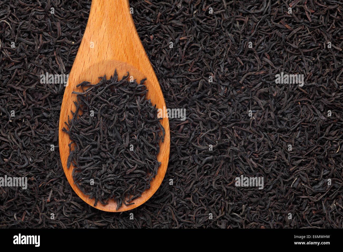 Black tea in a wooden spoon on a black tea background Stock Photo - Alamy