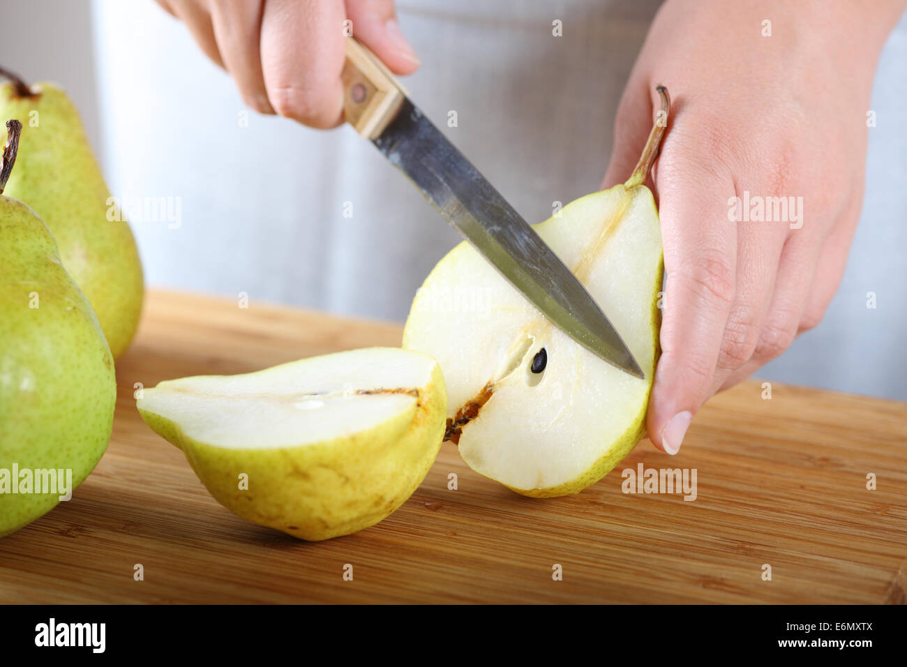 Woman's hands cutting pear Stock Photo - Alamy